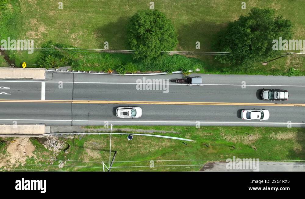 Amish horse and buggy in slo-motion. Top down aerial of car following ...
