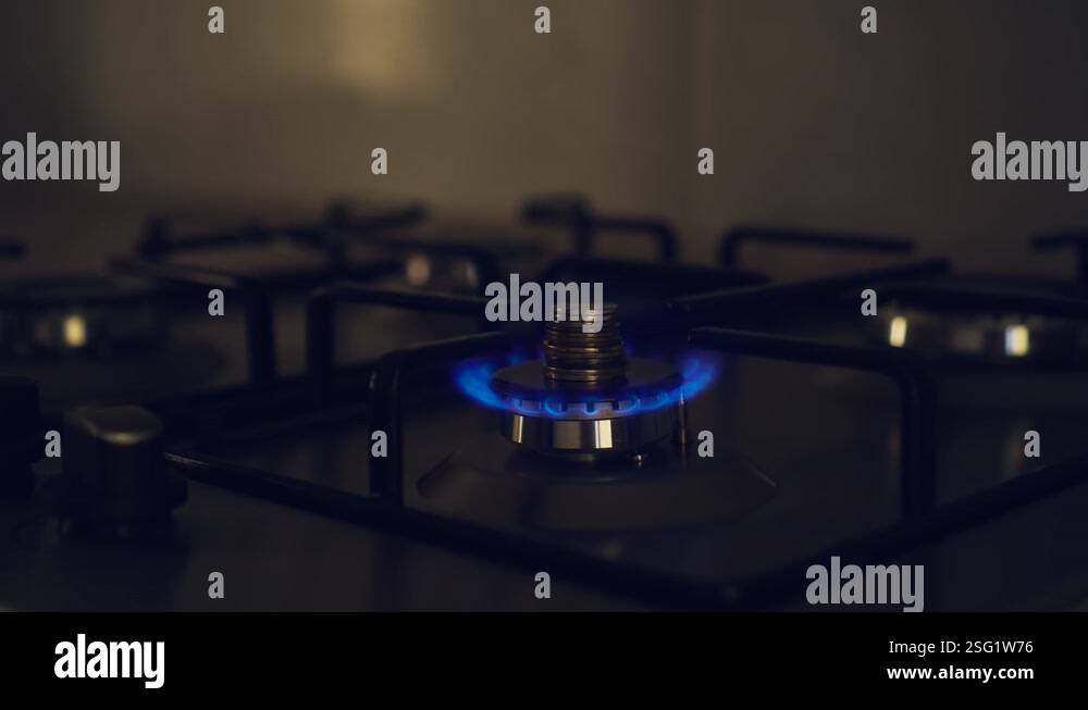 Flame of kitchen burner on stove with stack of coins and blue gas fire ...