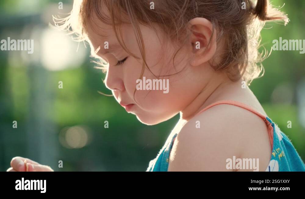 Profile view of Cute Little Girl Biting Snack but Doesn't Like Taste ...