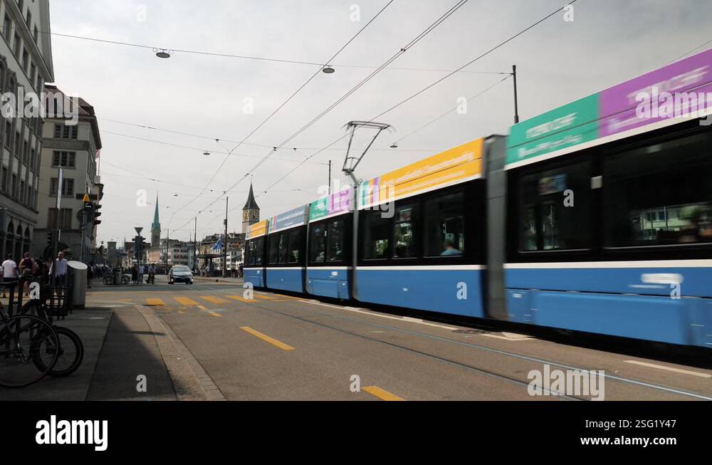 Modern passenger tram driving along riverbank in Zurich, Switzerland ...