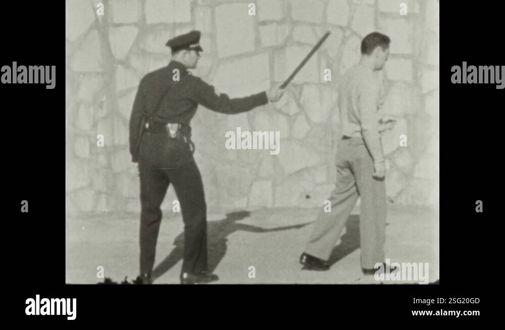 1940s: Police officer demonstrates baton strike locations on back of ...