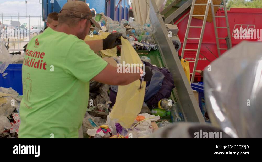 Workers sort garbage on a conveyor at a mobile waste sorting point at ...