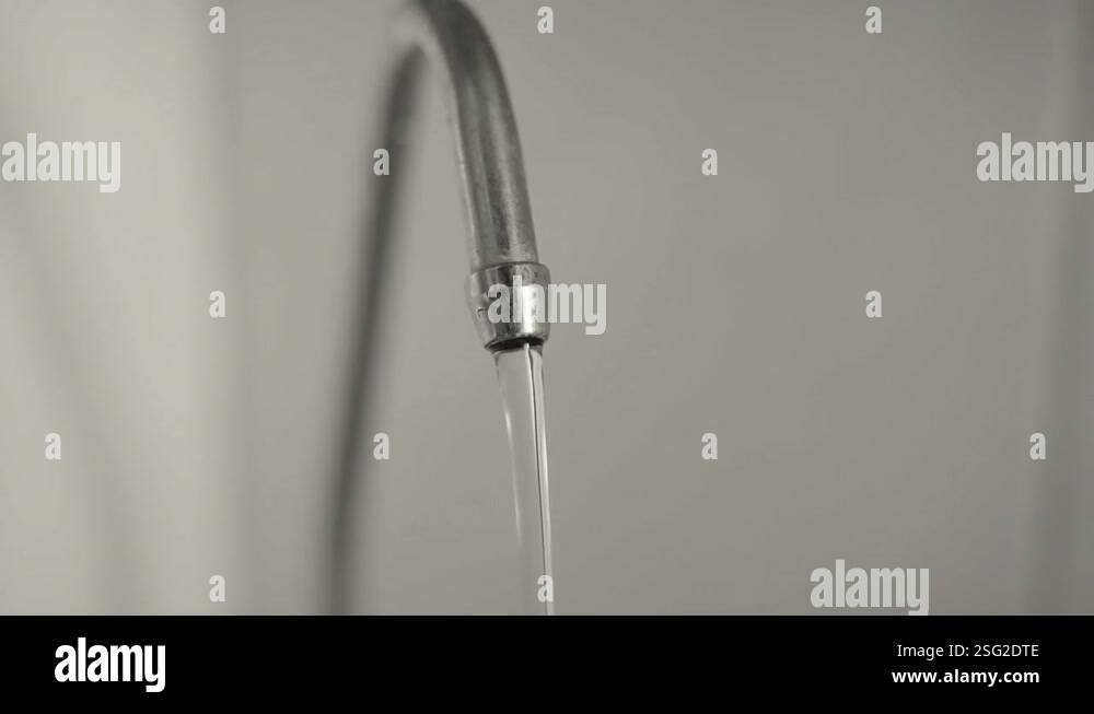 Macro, a jet of water flows from a metal kitchen faucet and turns into ...