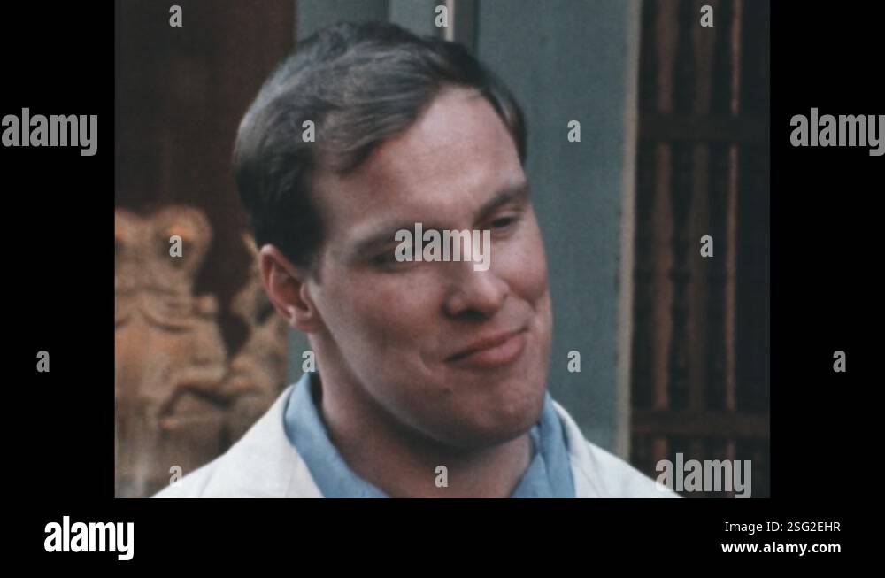 1960s: Office, women type on adding machines. Man holds microphone ...