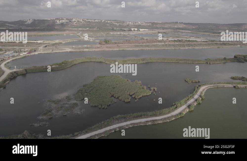 Parallax aerial view of an island with vegetation in fish ponds on the ...