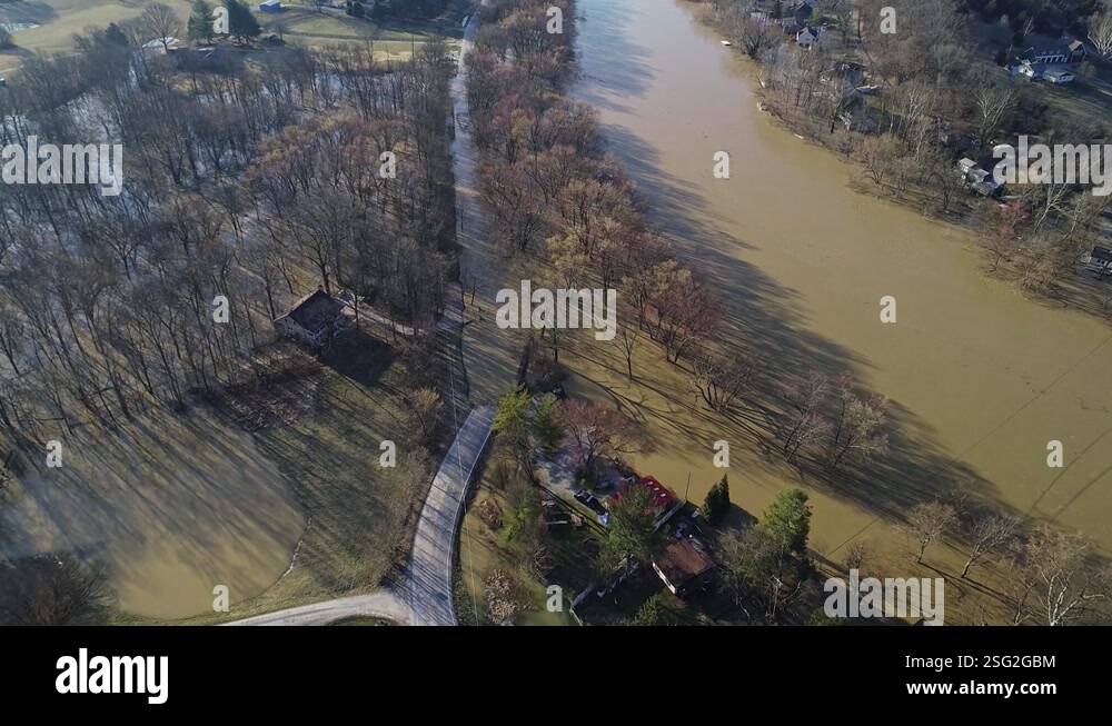 aerial top down view of river overflowing closing the street and road ...