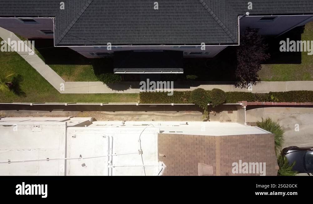 Top-down rising aerial of house yard and pathway over the roofs of ...