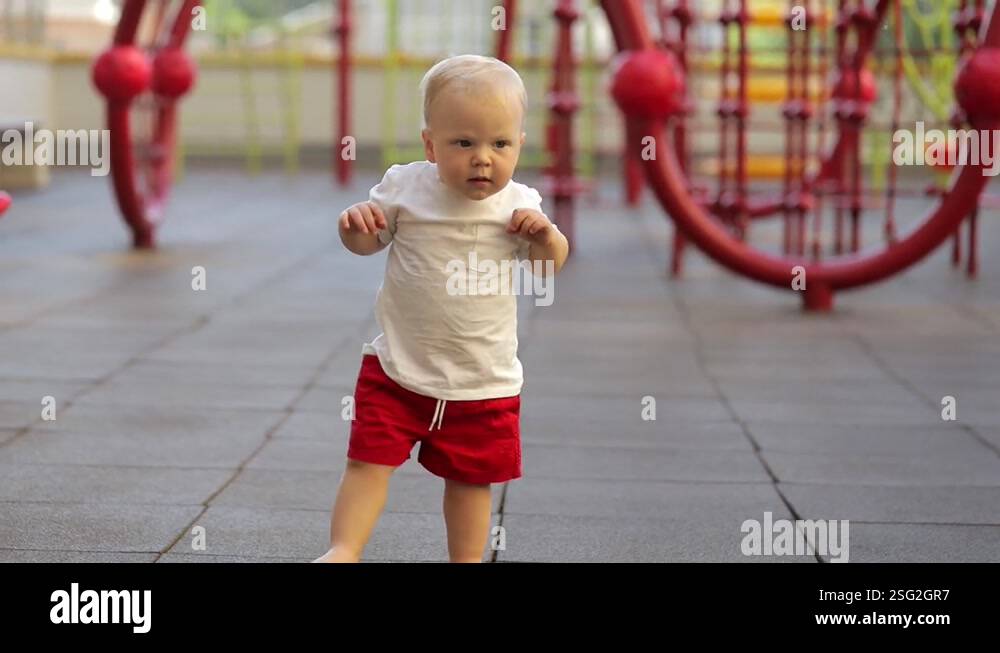 Blond boy taking first steps at playground, learning to walk Stock ...