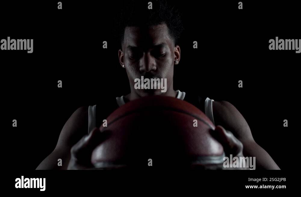Basketball player sitting on a bench taking deep breath in ...