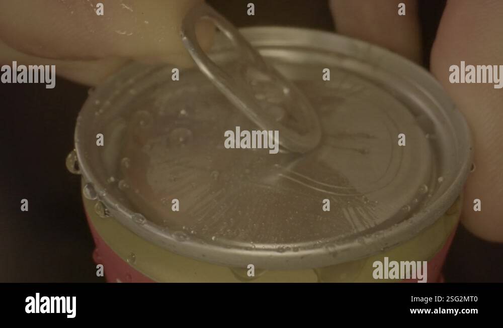 Macro shot of lid of soda can being opened in slow motion and spilling ...