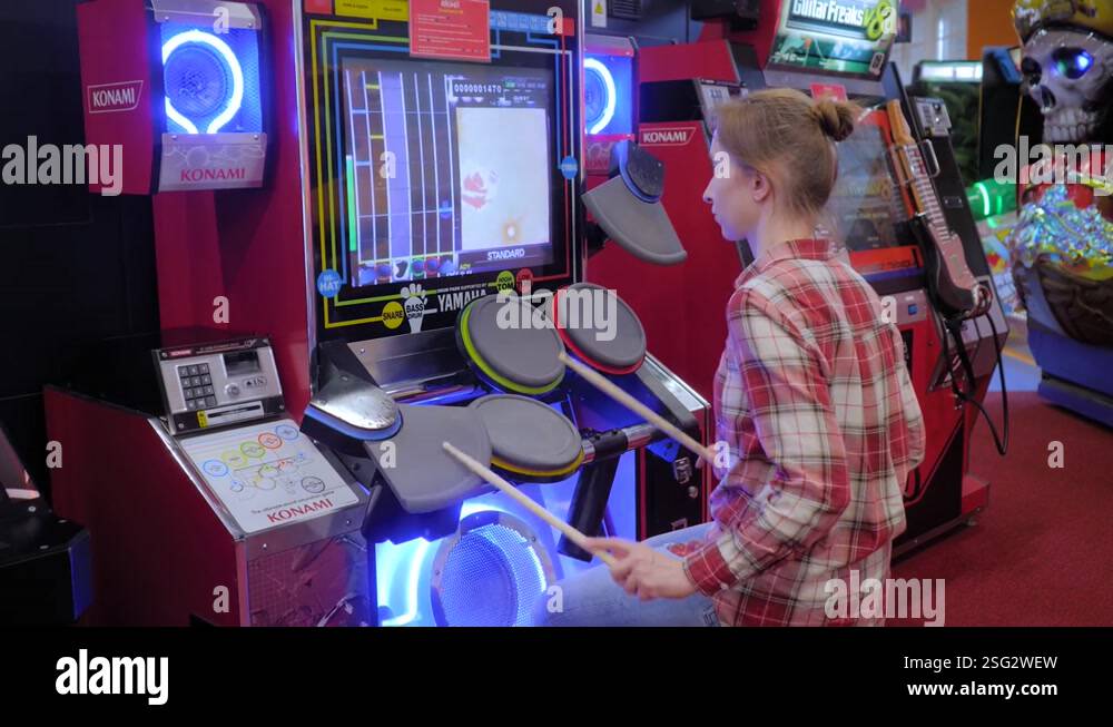 Woman gamer using drum sticks joystick, playing retro rhythm drum ...