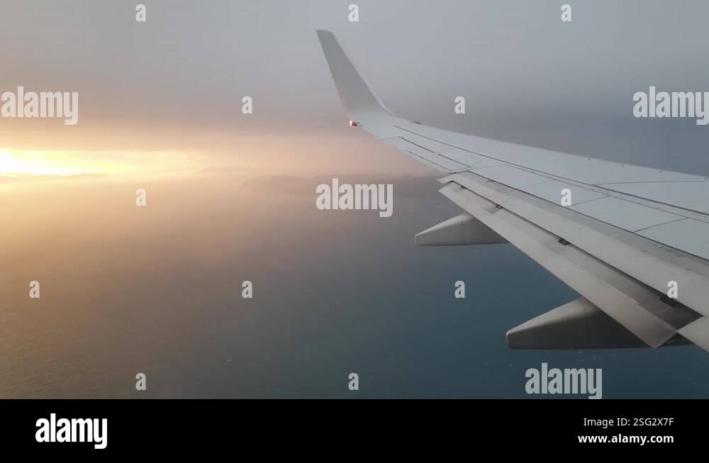 A stunning sunset seen from the airplane window looking over plane wing ...