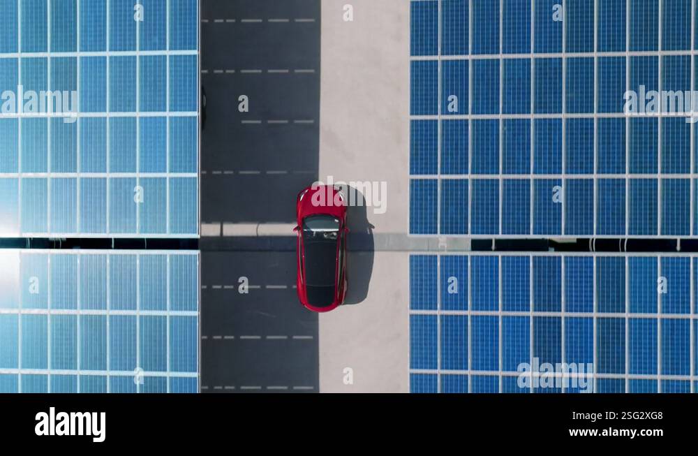 Overhead shot of red electric car driving by charging station, electric ...
