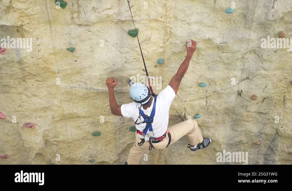 one man is playing wolltopia Rock climbing walls game on a cruise in ...
