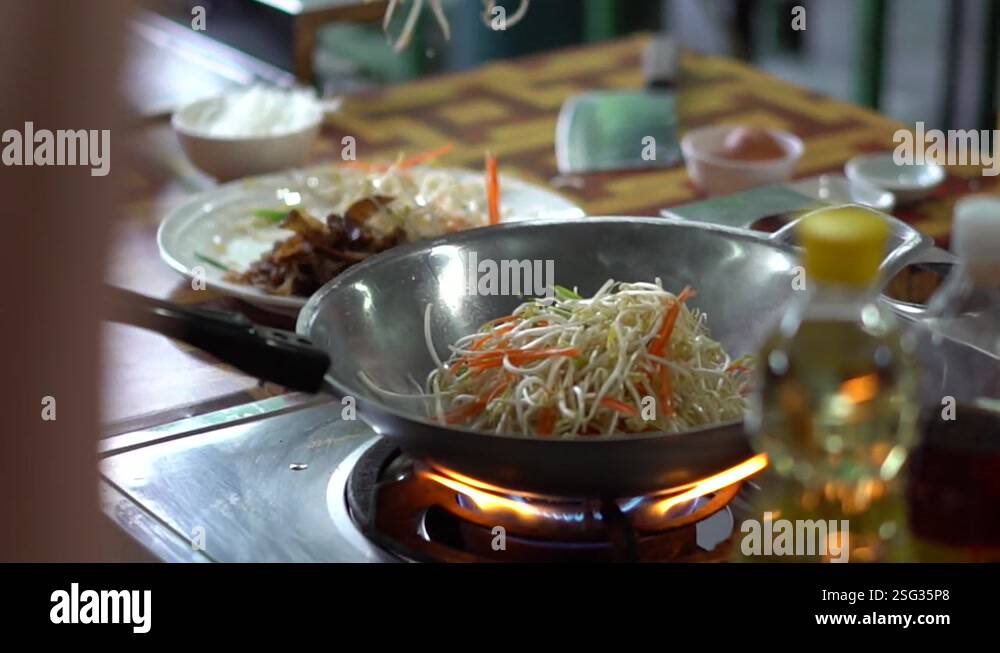 Person Putting Handfuls of Vegetables into a Wok on a Stove High Heat ...