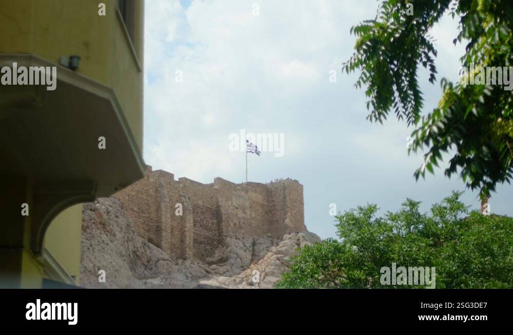 Greek flag waving in the distance on top of an ancient fort in Athens ...