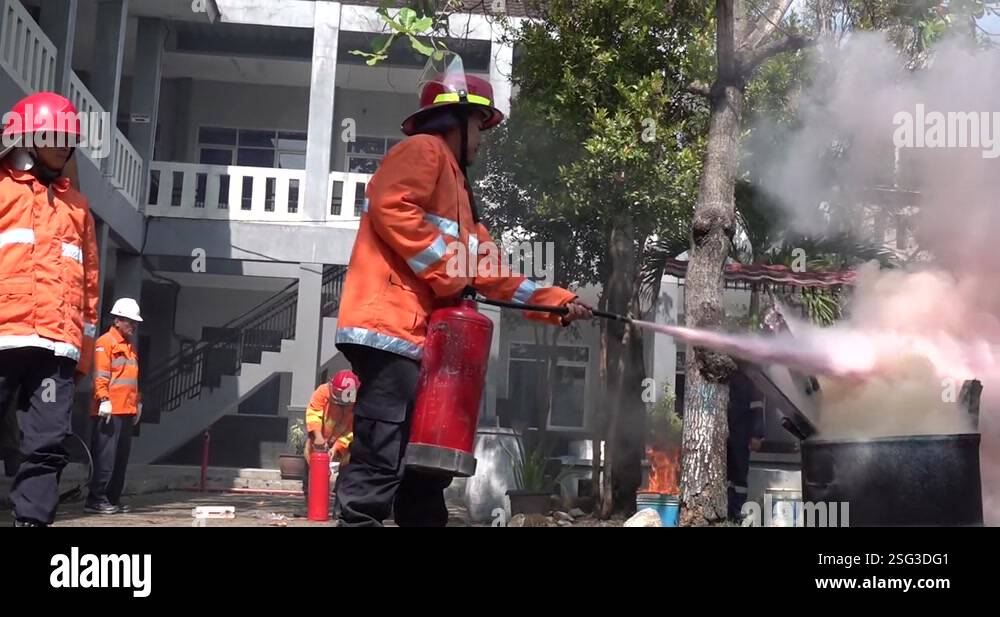 Some firefighters practises how to use a fire-extinguisher by using ...