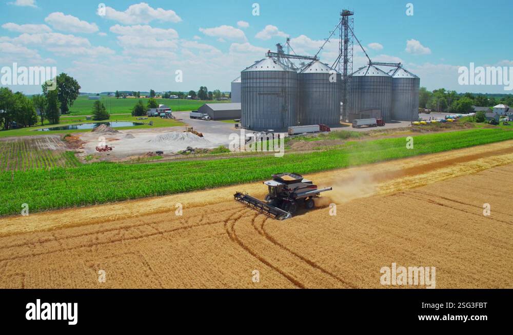 Drone shot of farmer harvesting wheat field in Ohio with grain elevator in Stock Video Footage ...