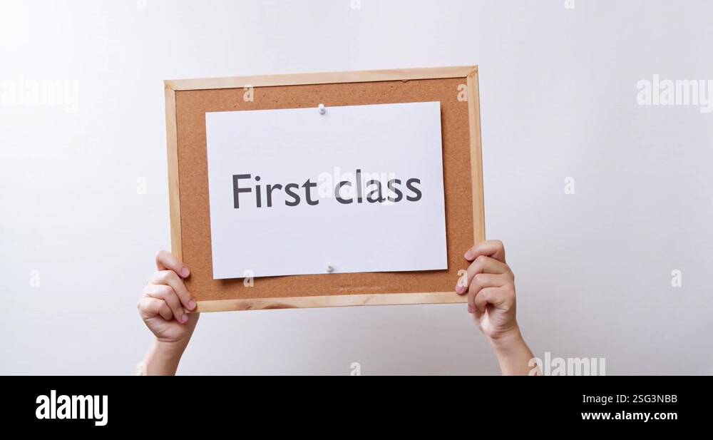Woman's hand shows the paper on board with the word First class in ...