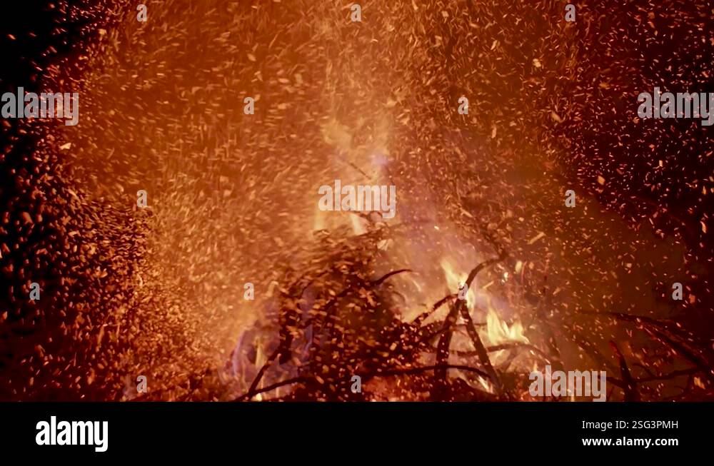 Hot fire flames with flying glowing bonfire embers in the dark night ...