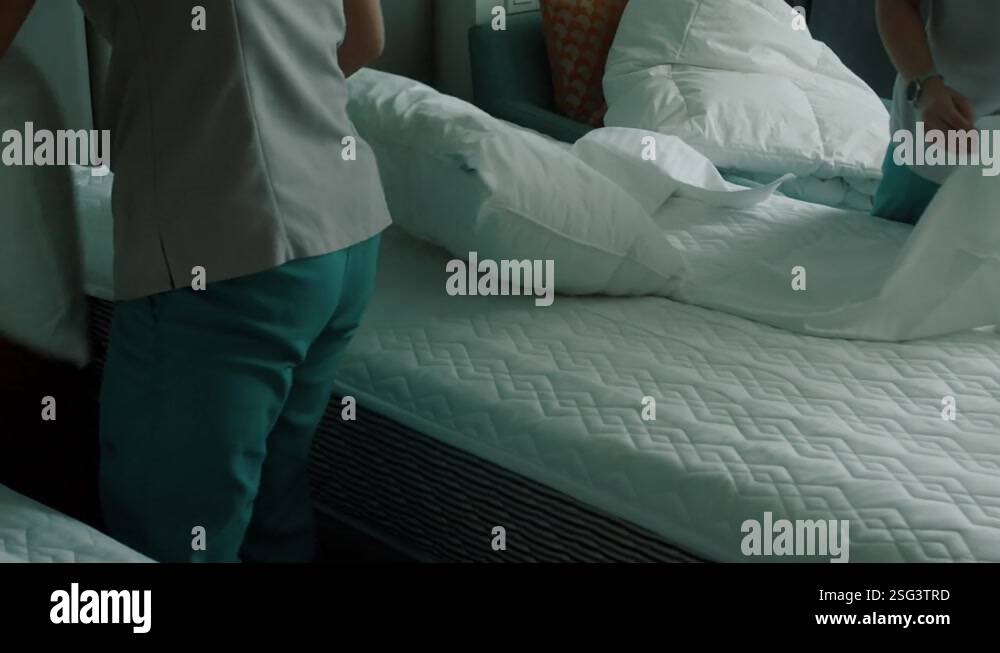 Womans changing the bedding in the room.Employees, two maids of the ...