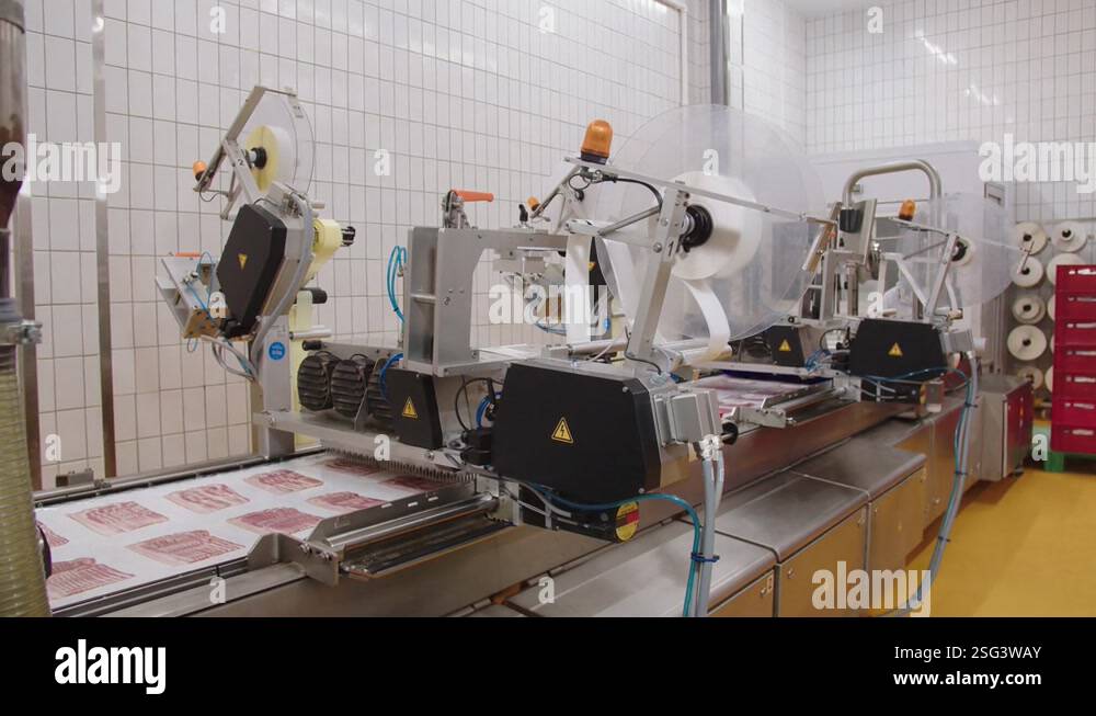 Machine for sticking labels on packaging. Thinly sliced bacon being ...
