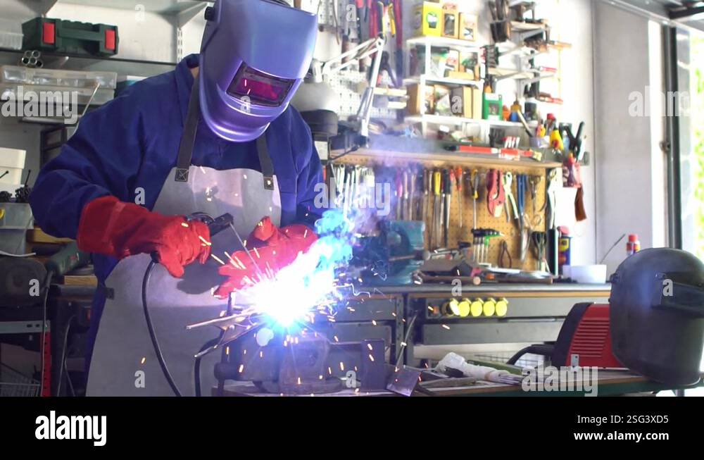 Slowmotion of worker in special clothes and helmet works as welding ...
