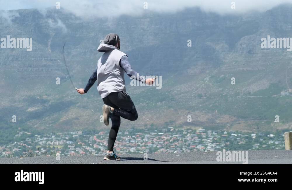 Fit man training on skipping rope outdoor. Male athlete training with ...