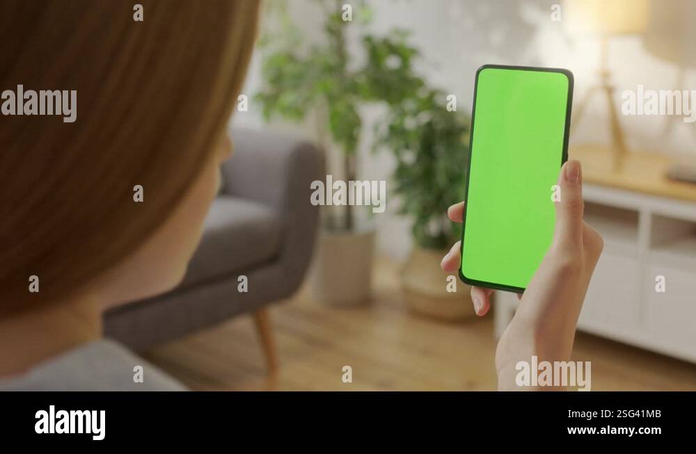 Handheld Camera: Back View of Blond Man Holding Chroma Key Green Screen ...