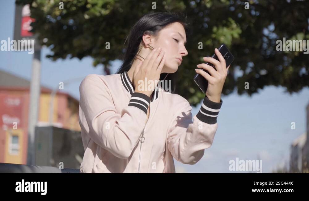 A young beautiful Caucasian woman checks herself and fixes herself on ...