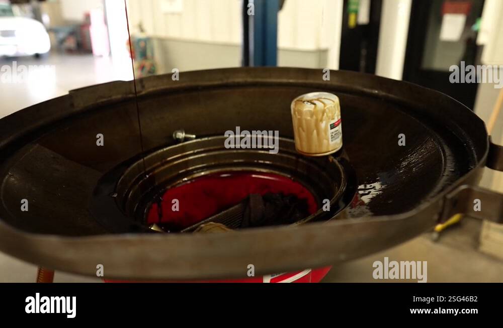 Oil drains into oil pan, panning shot. Car mechanic repair service ...