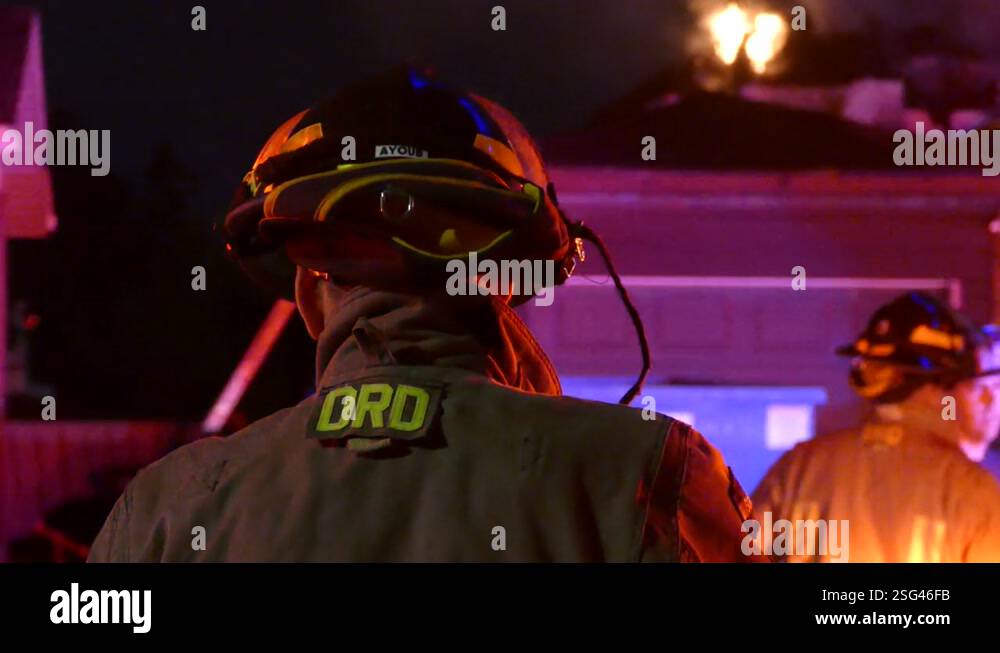 Visible flames on the roof of burning house as crews work hard to bring ...