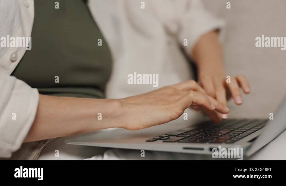 Woman typing on gray laptop on keyboard in close-up with laptop in her ...