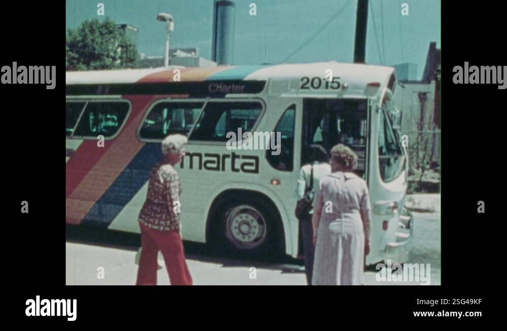 1980s: Bus kneeling to sidewalk. Elderly women embarking bus. Feet ...