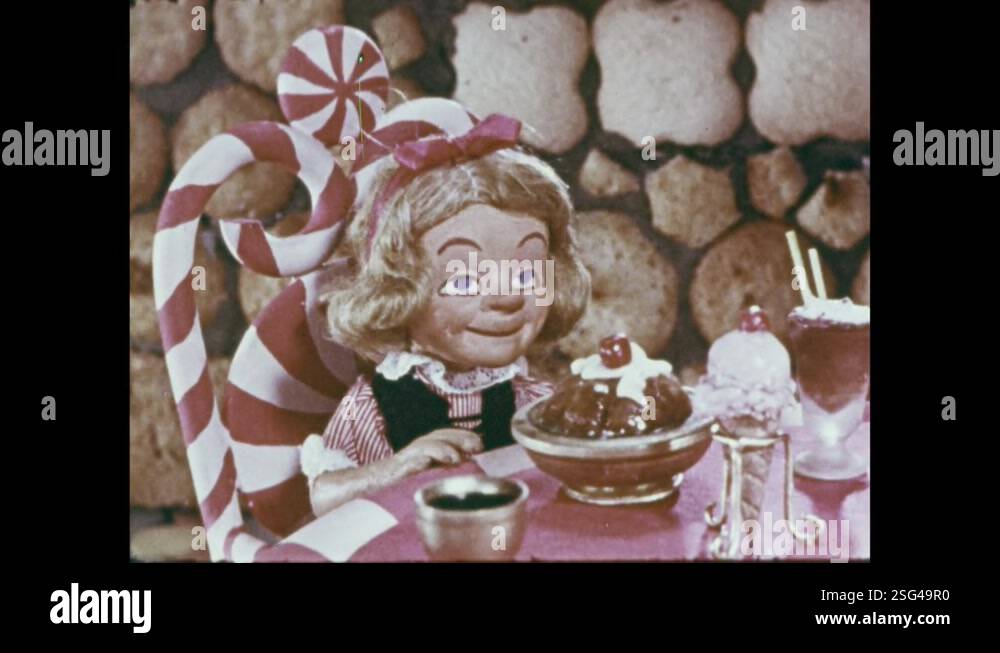 1950s: Stop-motion puppet animation- Girl sits at candy table, witch ...