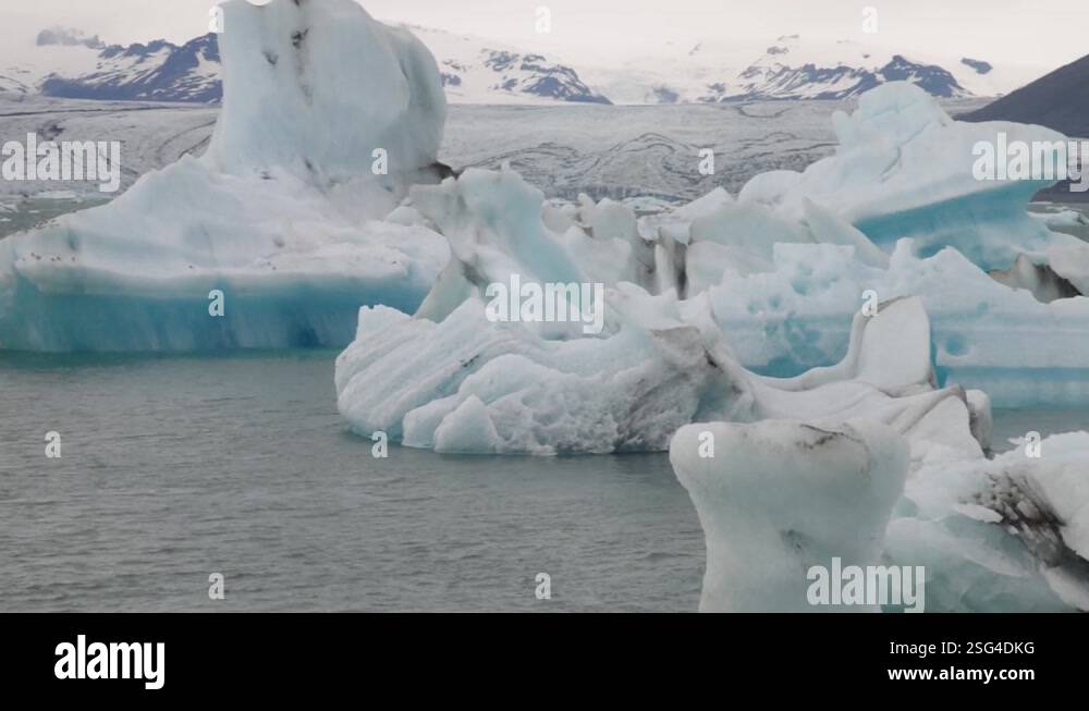 Glacier Lagoon in Iceland with close up pan left to right of ice chunks ...