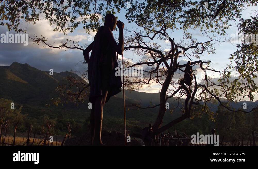 Suri tribe man standing on a giant rock in a sunny light, Omo valley ...