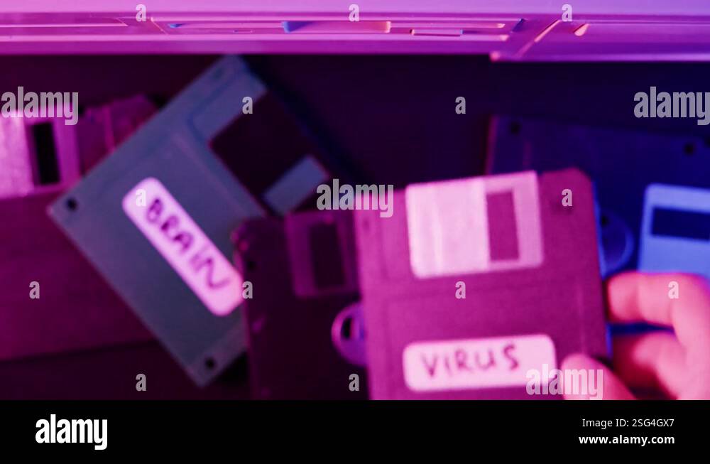 Using diskette with virus close-up. Old floppy disk, disc drive top ...