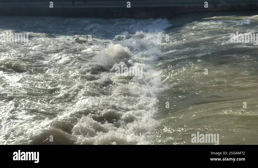 Extreme slow motion view of powerful river water flowing down a weir ...