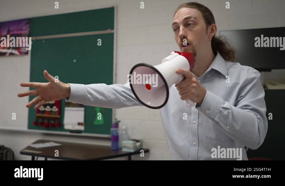 Angry teacher shouting in classroom into megaphone loudhailer, bullhorn ...
