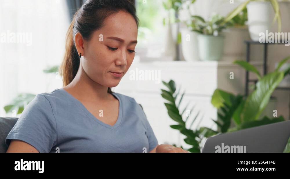 Asian woman site on couch use laptop surprise with high score exam test ...