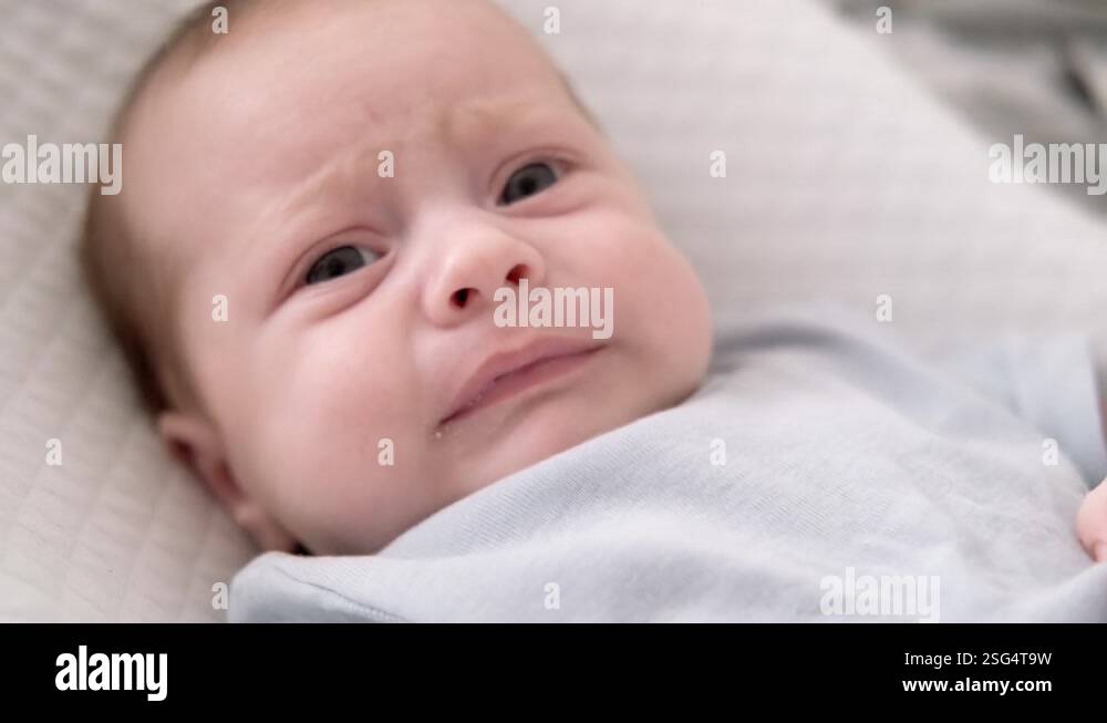 Dissatisfied, crying, upset, sad Newborn baby boy lying in nursery ...