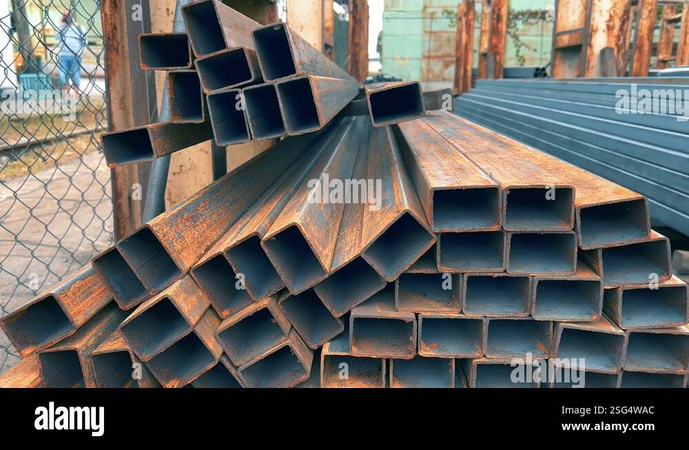 Square pipes or square tubing lie in a stack in storage of a rolling ...