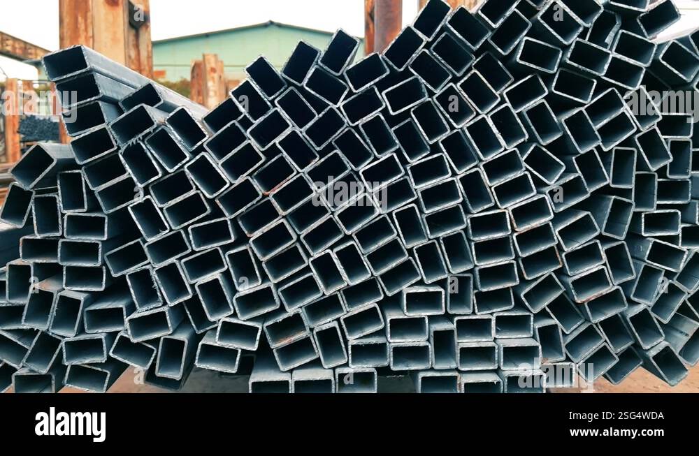 Square pipes or square tubing lie in a stack in storage of a rolling ...