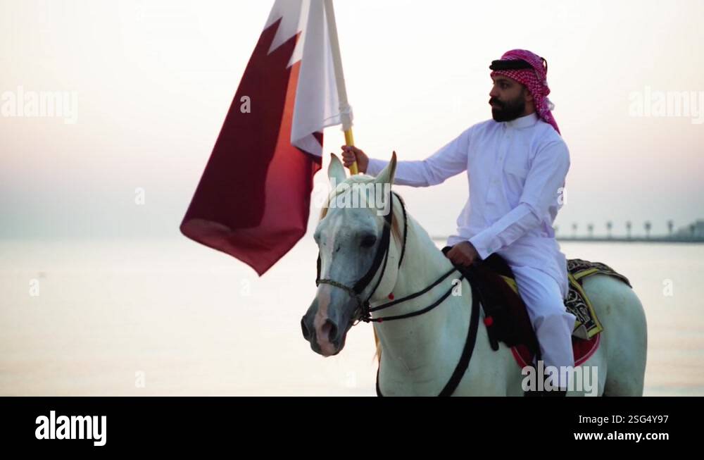 A knight on horse holding Qatar flag near the sea Stock Video Footage ...