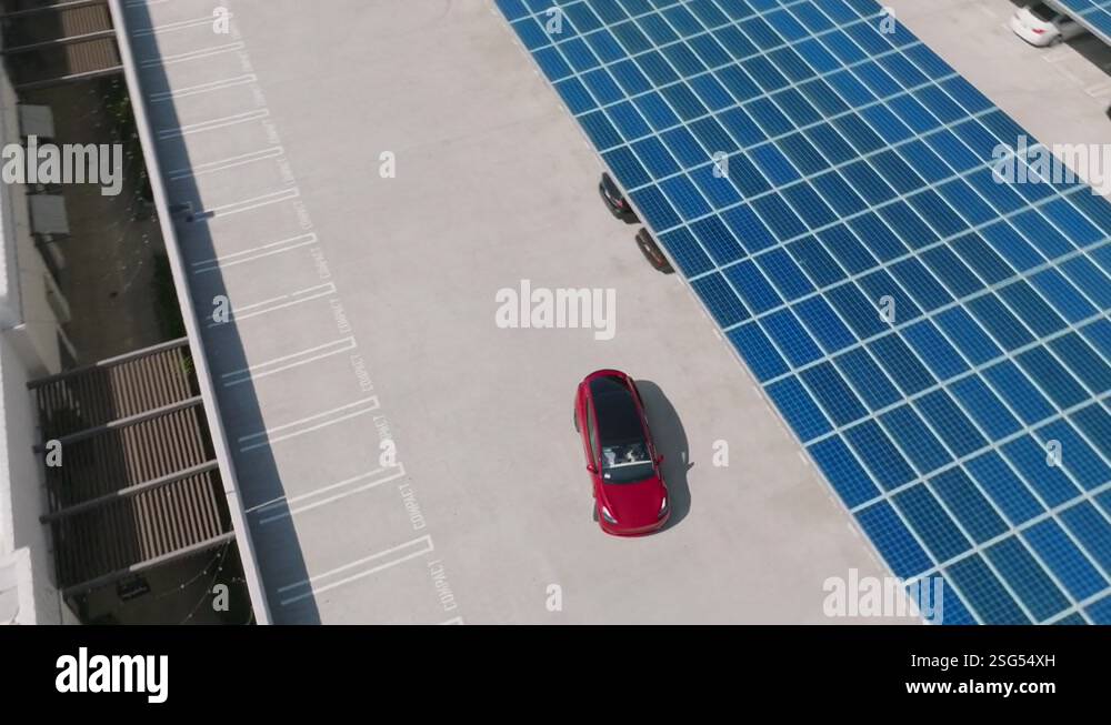 Cinematic aerial above red modern self driving car on rooftop solar ...