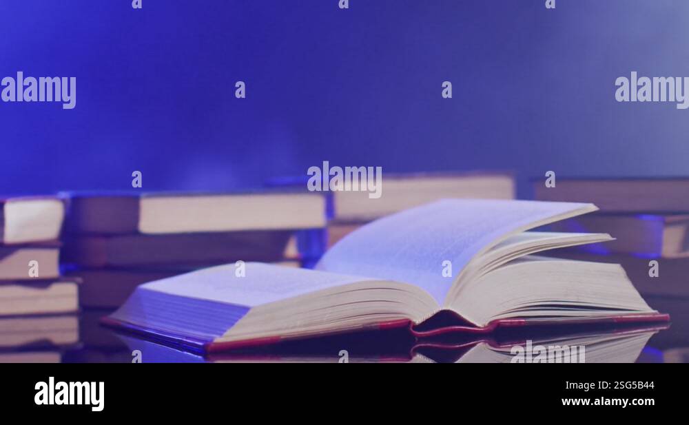 Video of pages in book moving over books and smoke on black background ...