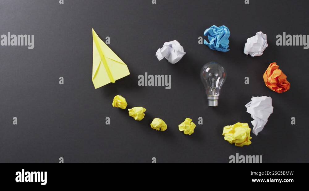 Video of colourful paper balls, light bulb and plane on black ...
