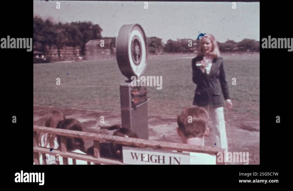 1970s: Kids sit in front of a scale as lady reporter speaks to camera ...
