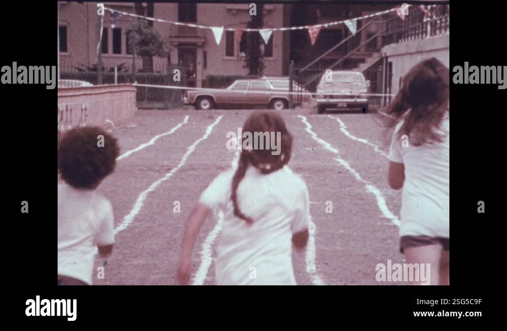 1970s: Boys and girls wait at starting line. Children run down the ...